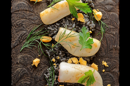 Black risotto cooked with squid ink featuring calamary, calamari, and ...