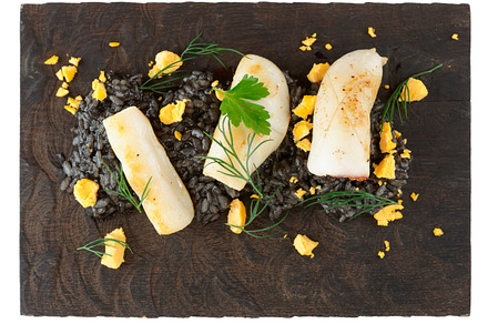 Black risotto cooked with squid ink featuring calamary, calamari, and ...