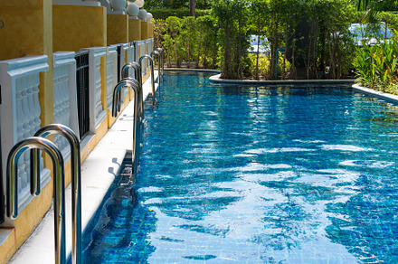 Blue swimming pool at hotel featuring pool, swimming, and tile, a ...