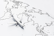 Plane flies above white paper map of the world travel background ...