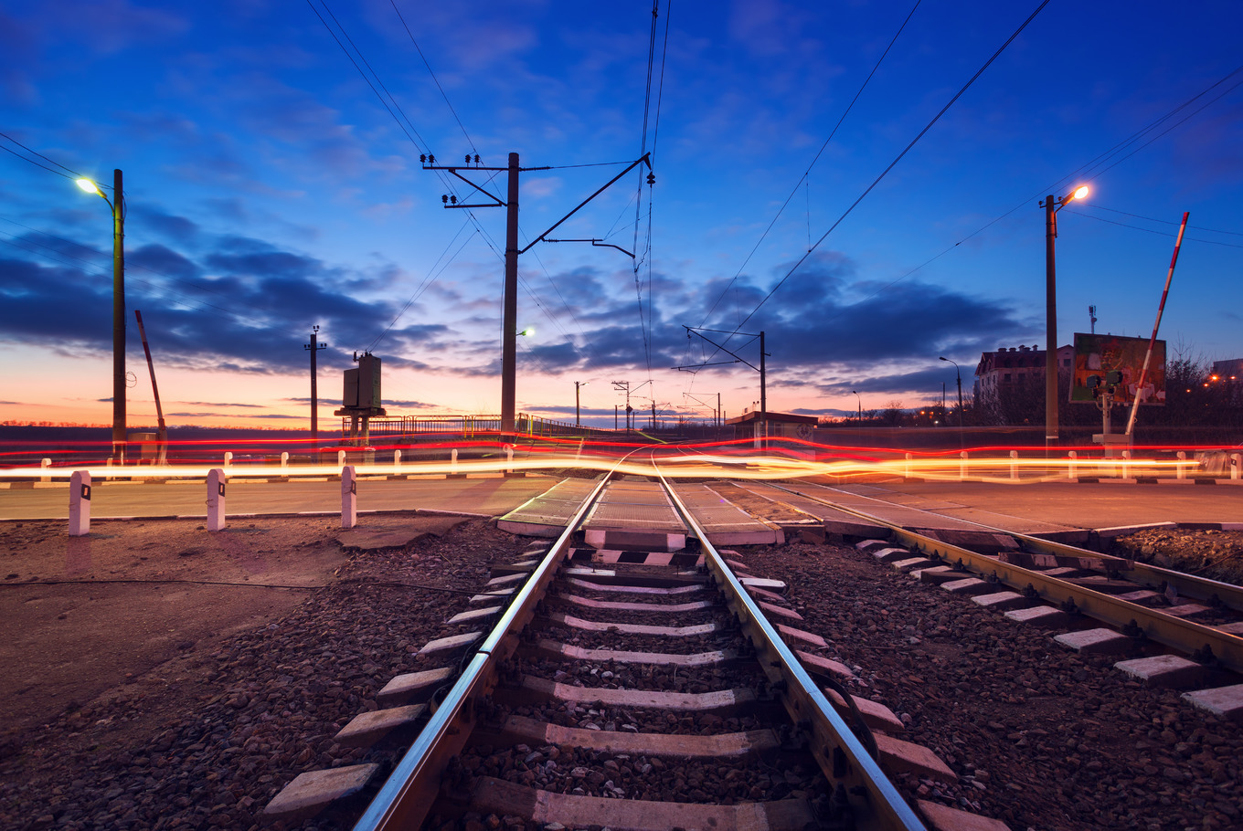 Railroad crossing at night featuring train, railway, and platform ...