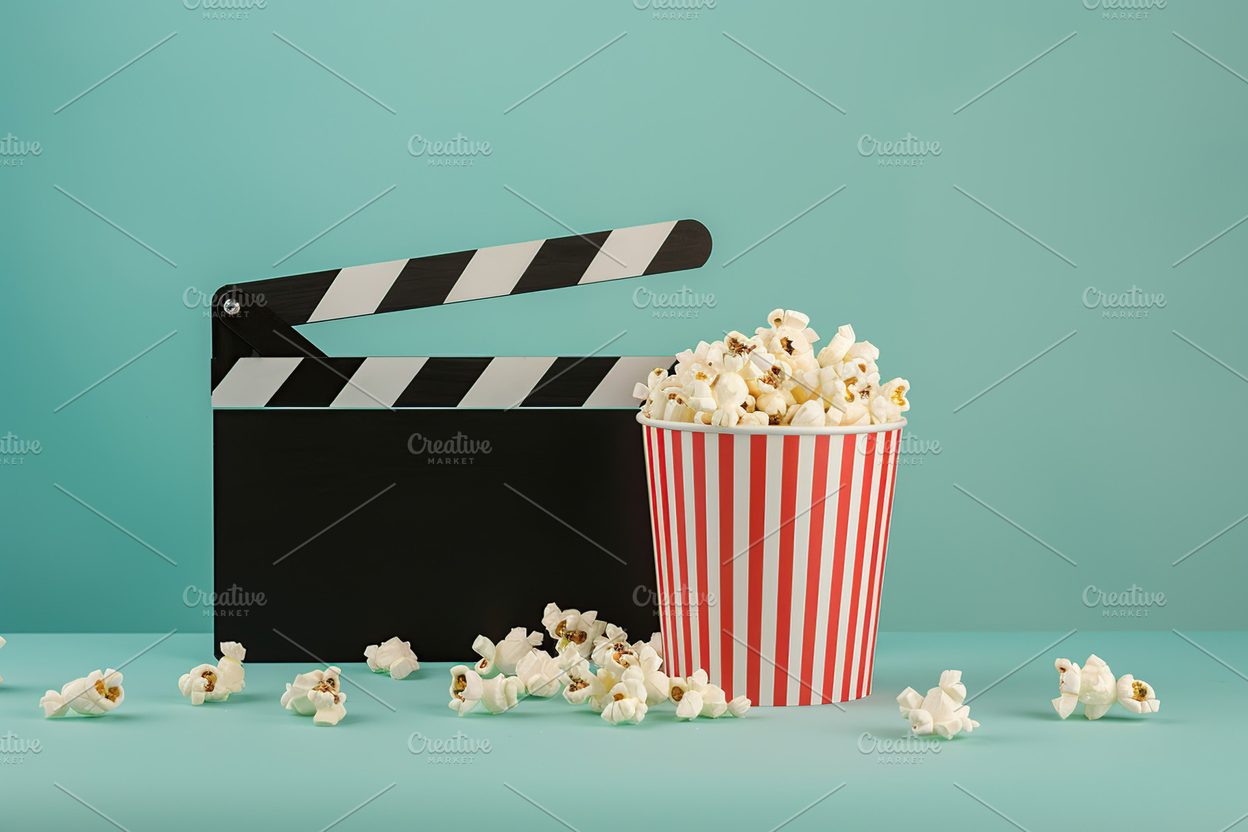 Black clapper board and bucket of popcorn on green background, a Food ...