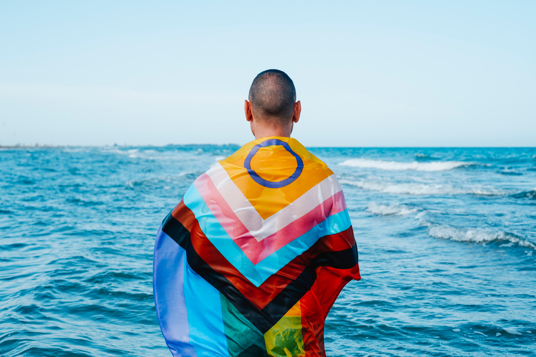 man wrapped in a wet progress pride flag, a Photo by Nito | Creative Market