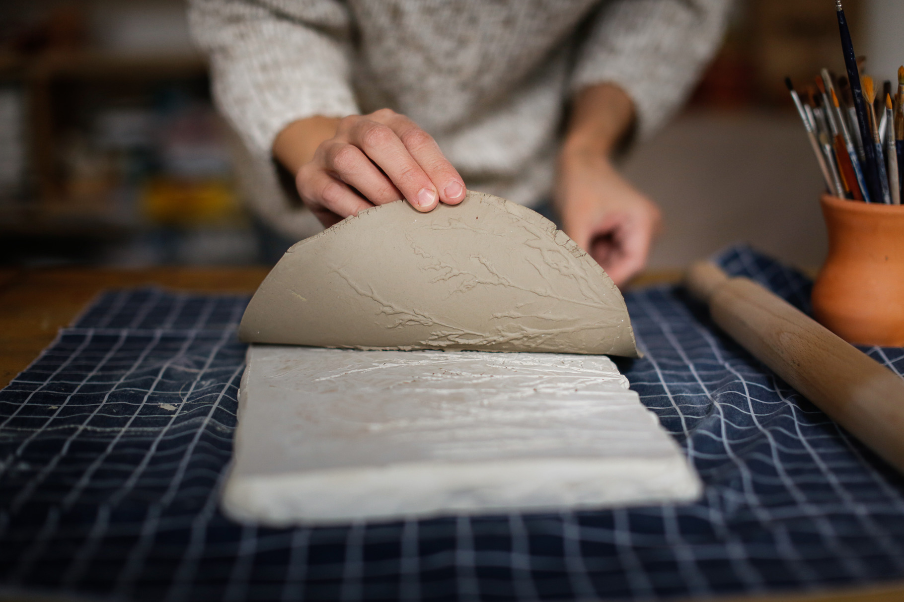 Craftsman tearing rolled clay from f | Holiday Stock Photos ~ Creative ...
