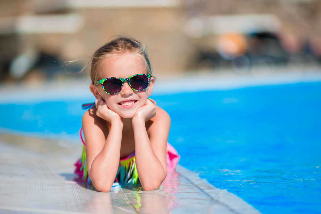 Adorable little girl at swimming pool having fun during summer vacation ...