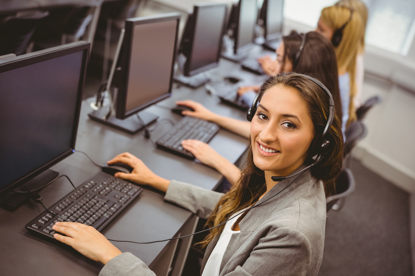 Smiling call centre agent talking on the headset, a Photo by wavebreak