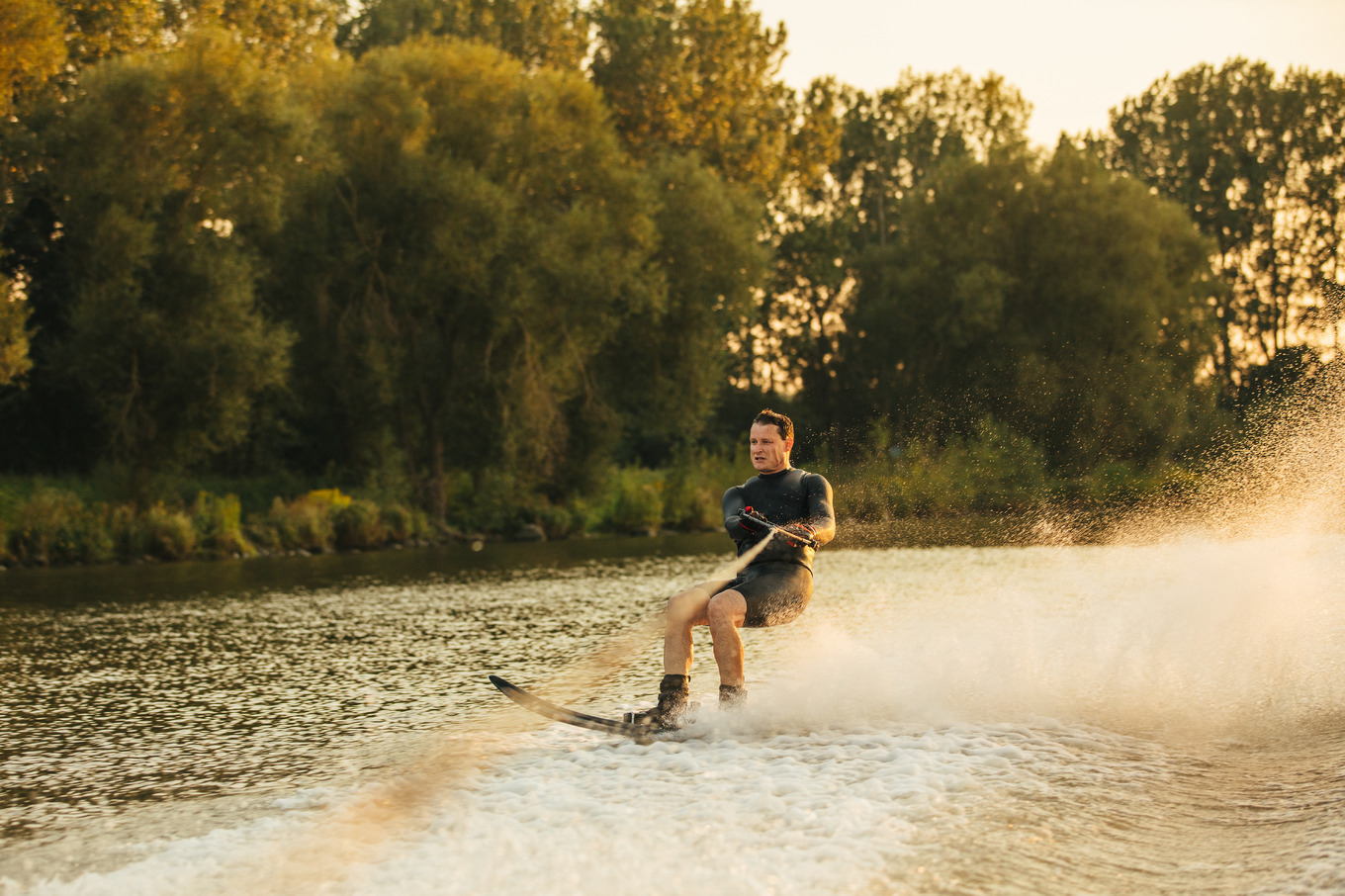 Man water skiing on lake containing action, activity, and adventure, a ...