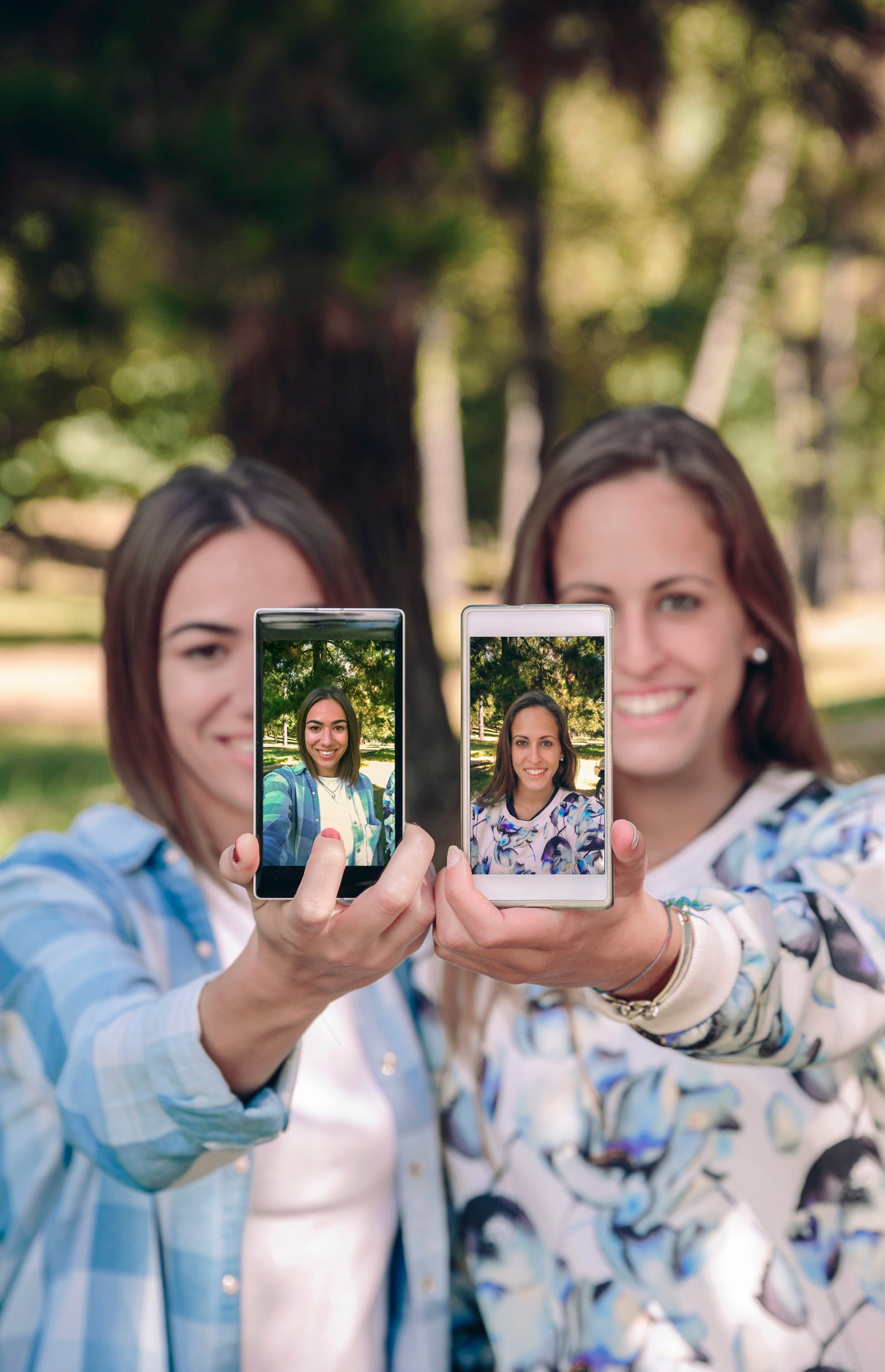Women showing smartphones with their selfie photos containing women ...