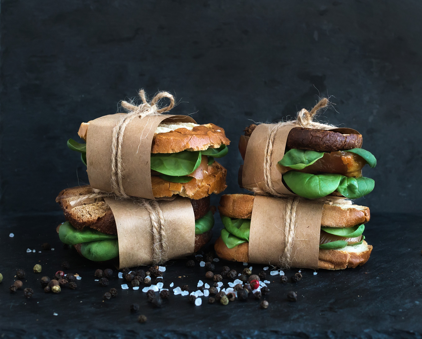 Sandwiches wrapped in craft paper containing bread, sandwich, and green ...