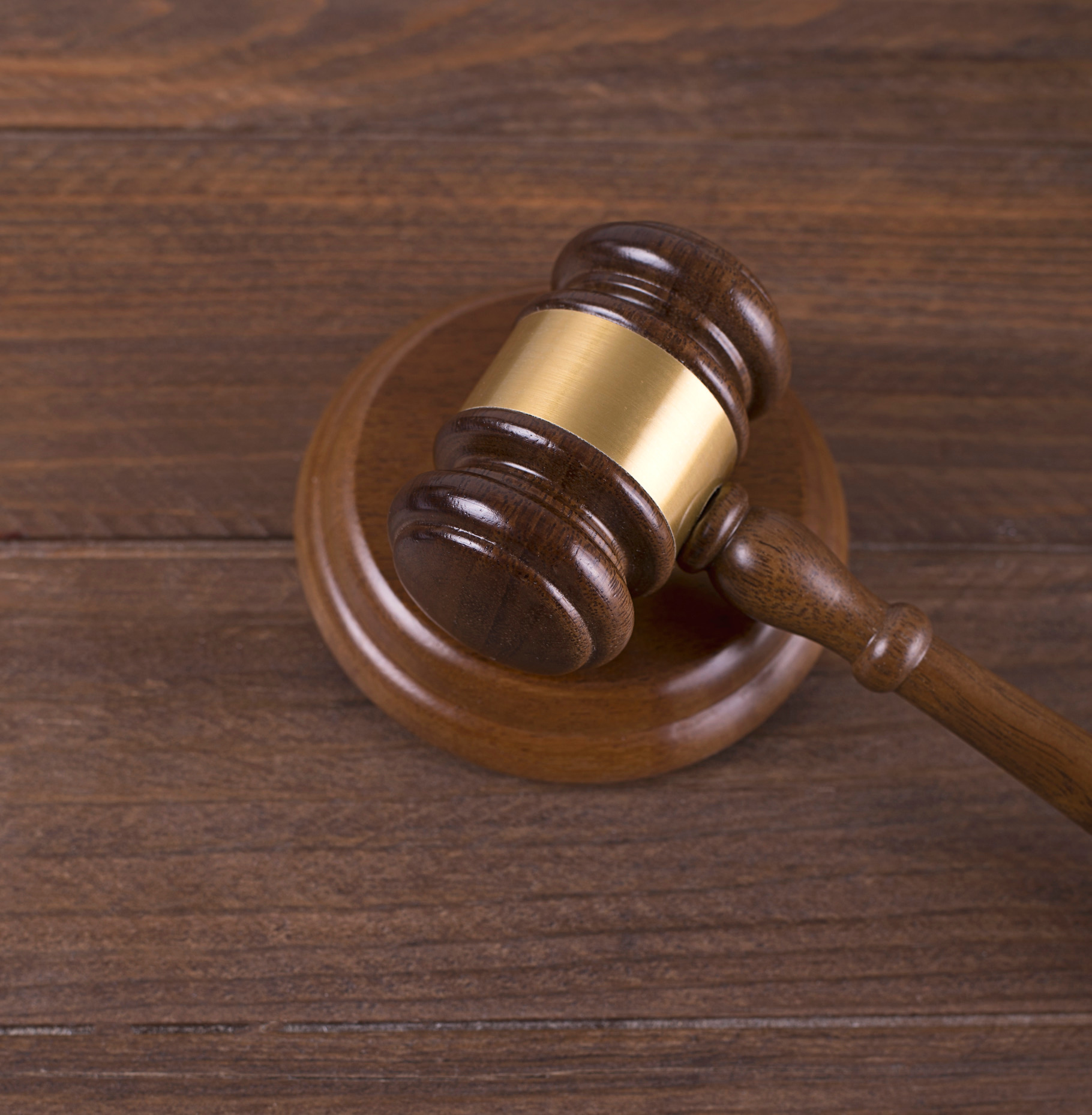 Wooden mallet used by a judge or at an auction on brown wooden table ...