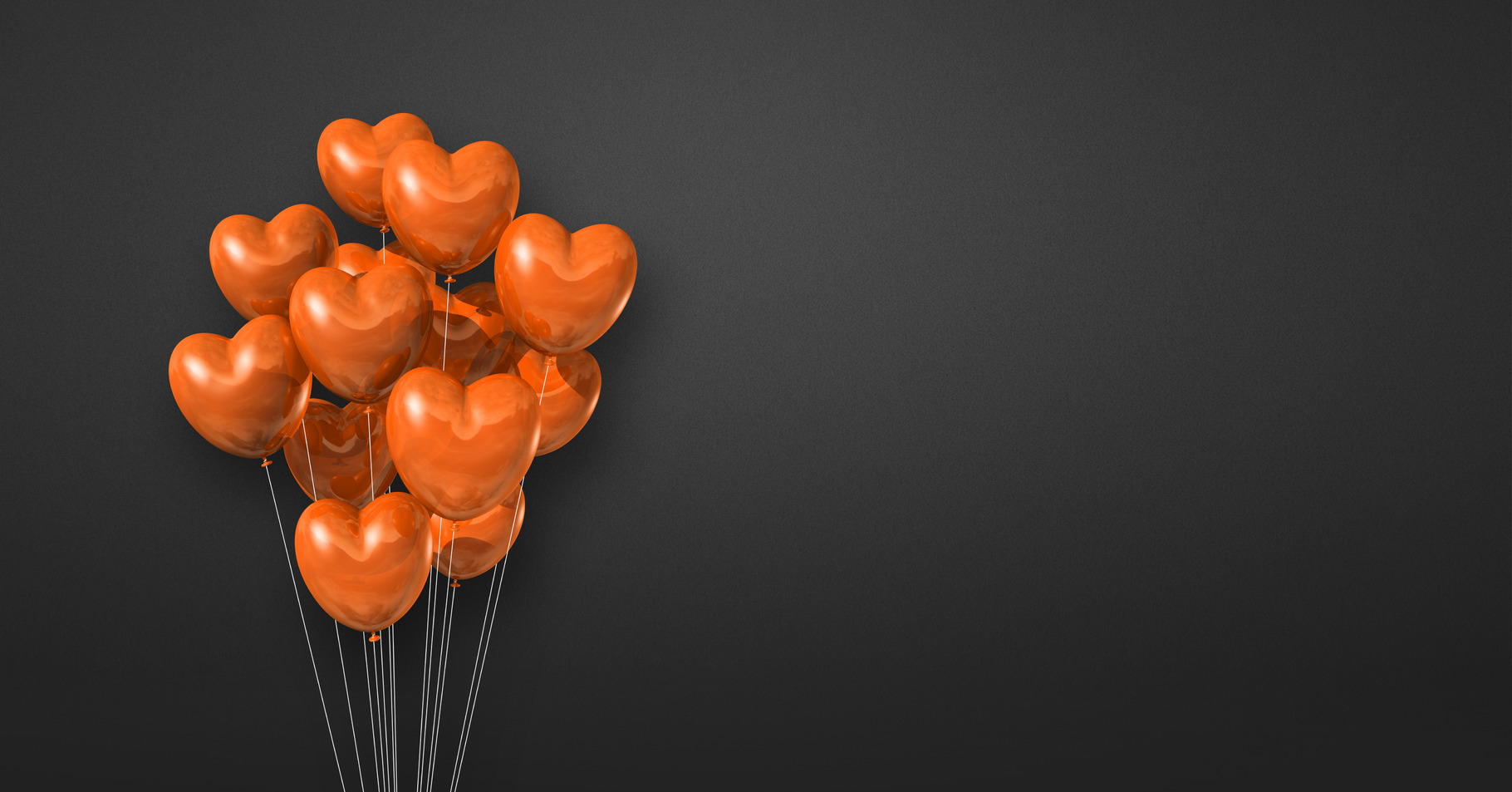 Orange heart shape balloons bunch on a black wall background. Ho, an ...