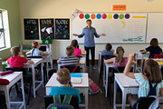 Teacher standing in a classroom, a Photo by wavebreak