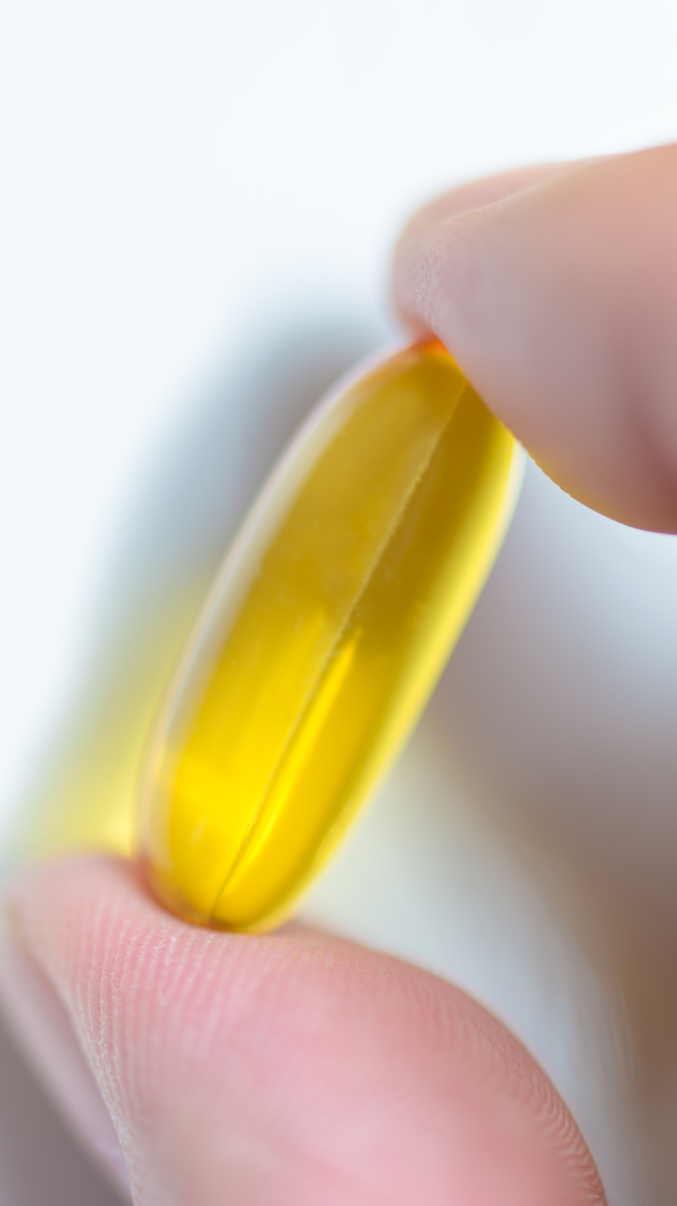 Fish oil macro closeup on finger, a Health & Medical Photo by PeoGeo Studio