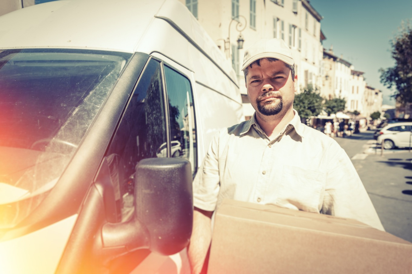 Messenger delivering parcel standing next to his van featuring ...
