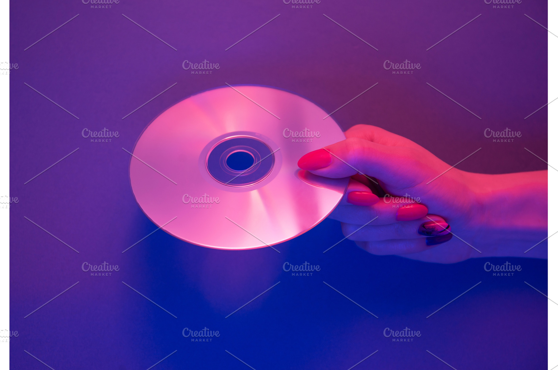 Woman hand holding CD disc in neon, a Technology Photo by P&G