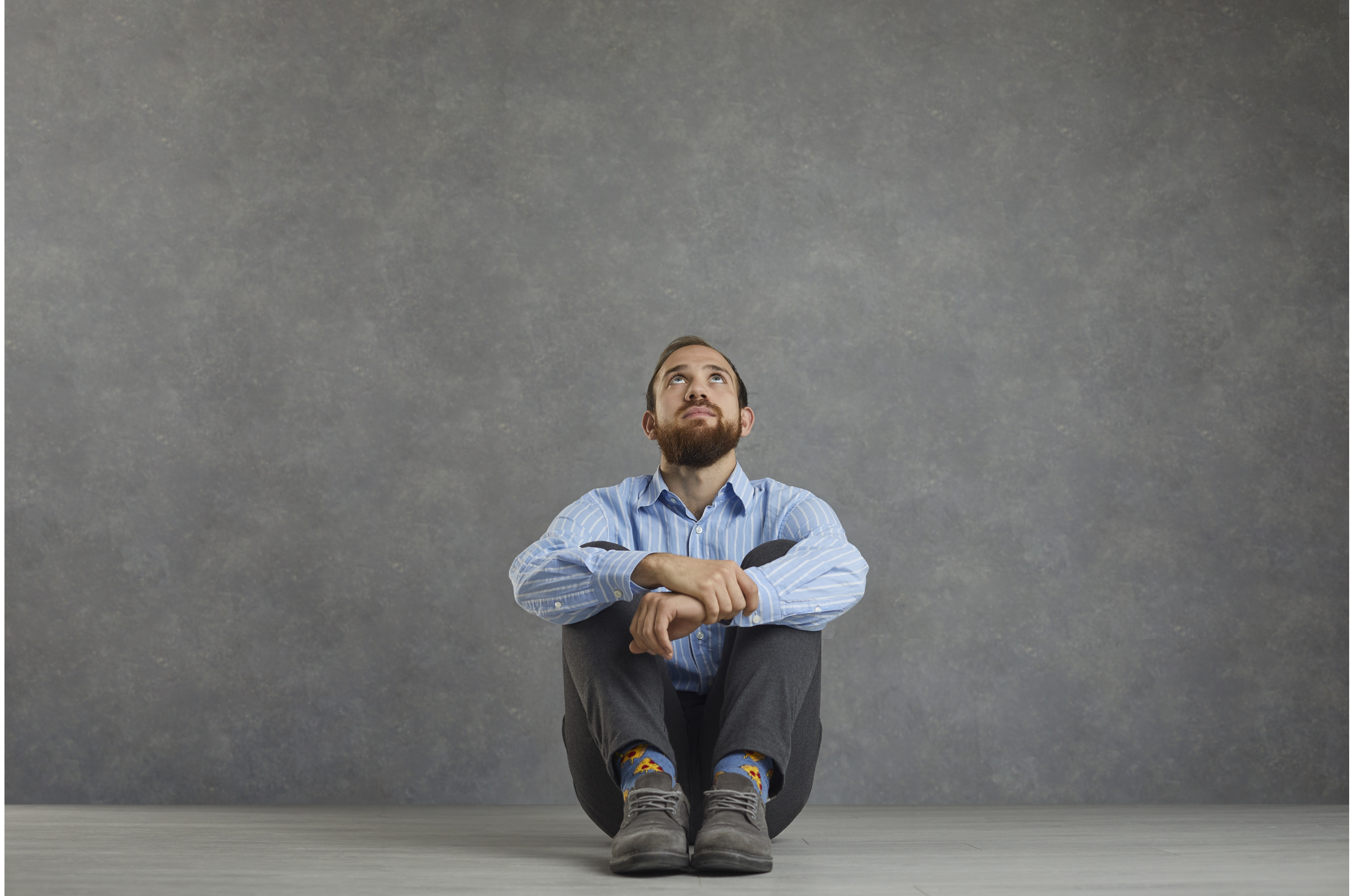 Relaxed man sitting on floor looking, a Person Photo by StudioRomantic