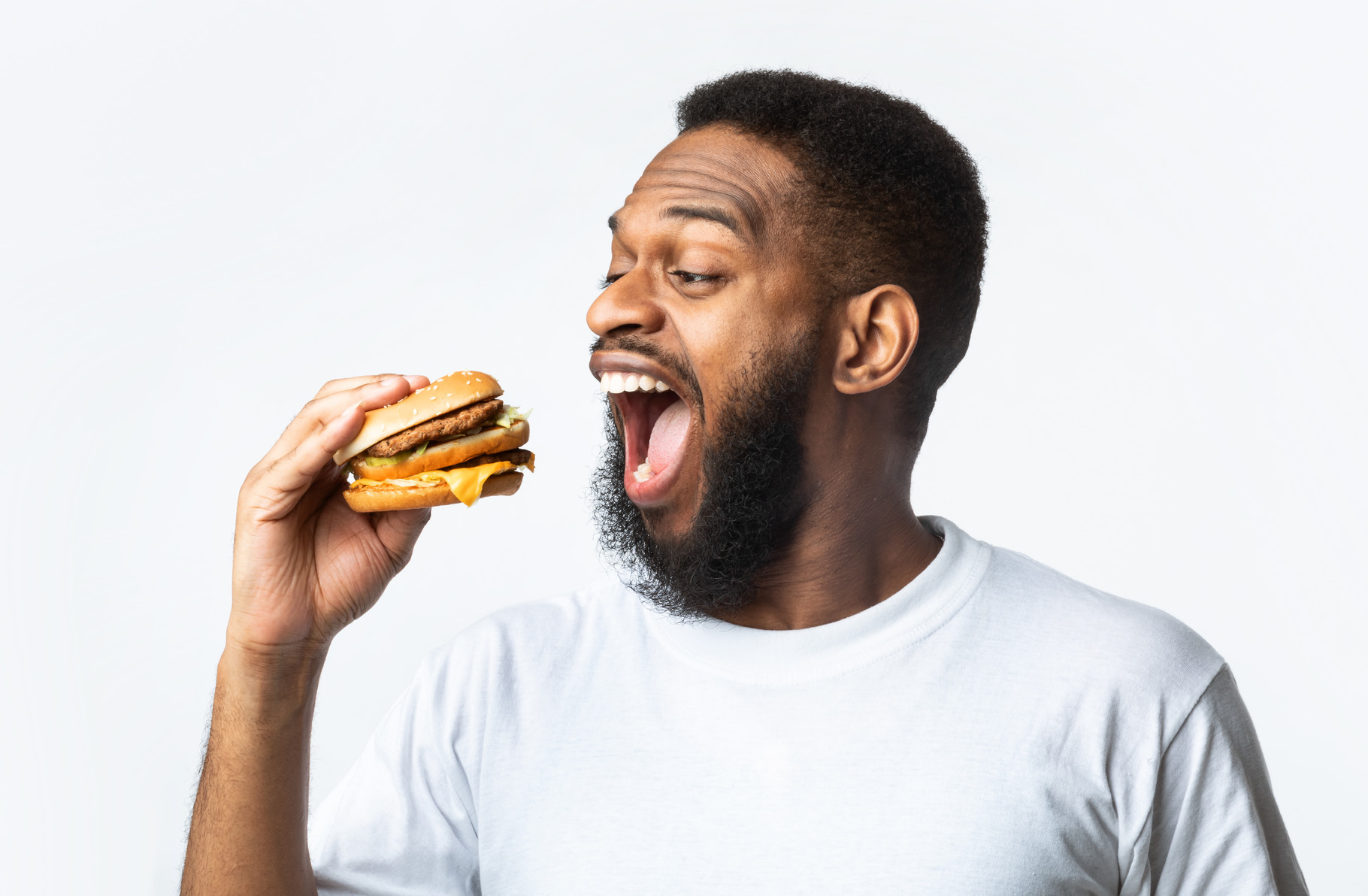 Hungry African American Guy Eating Burger Standing Over White ...