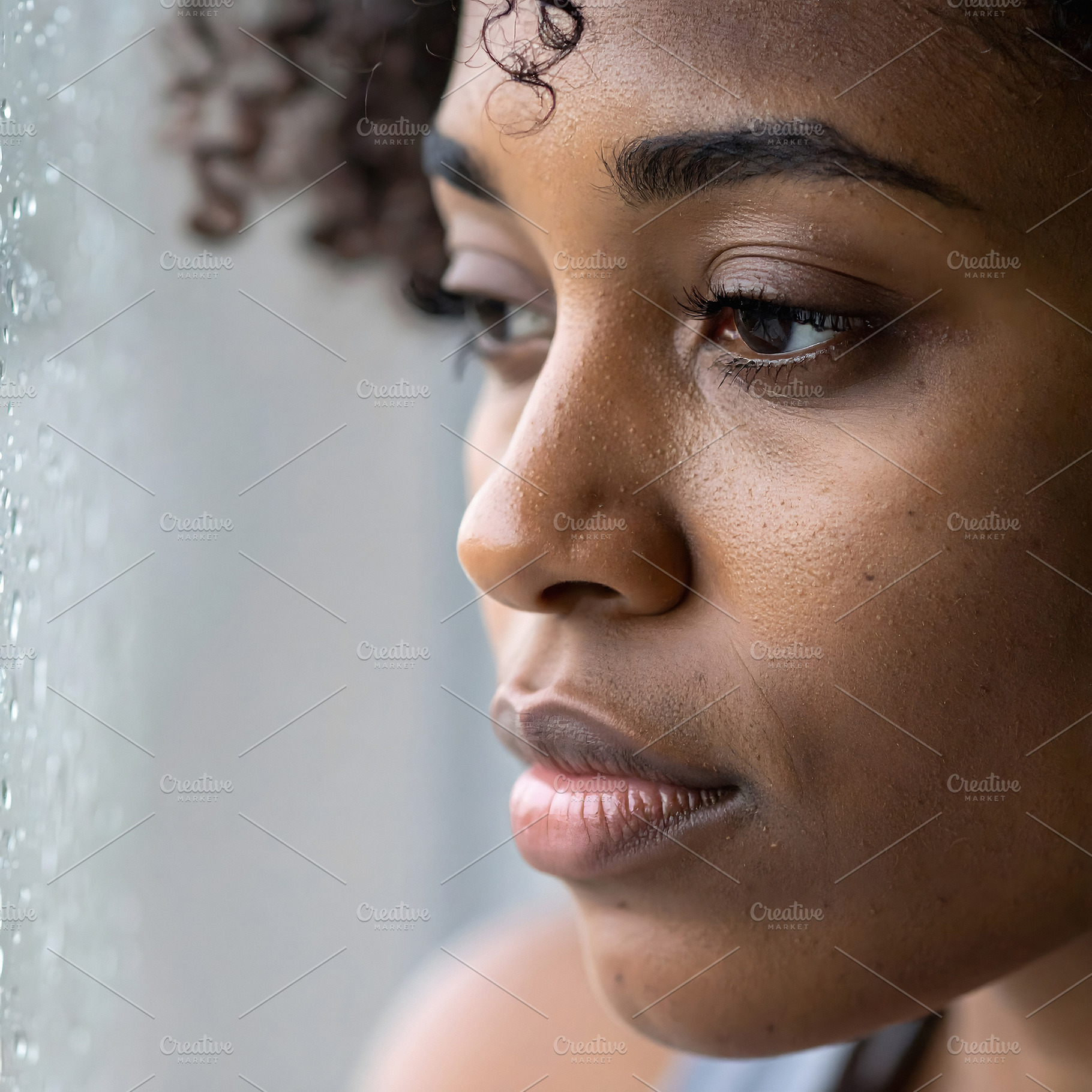 Woman looking outside through rainy window with thoughtful gaze, a ...