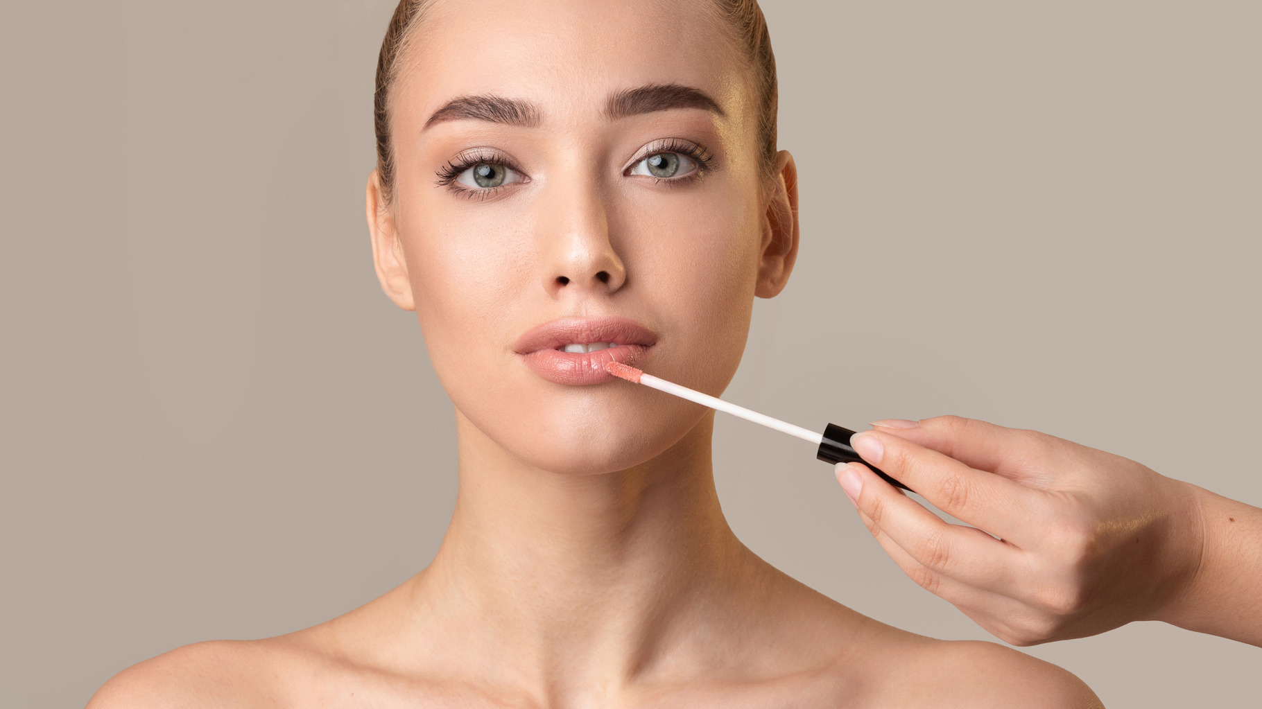 Model Girl Applying Lipstick Looking, a Background Photo by Prostock-Studio