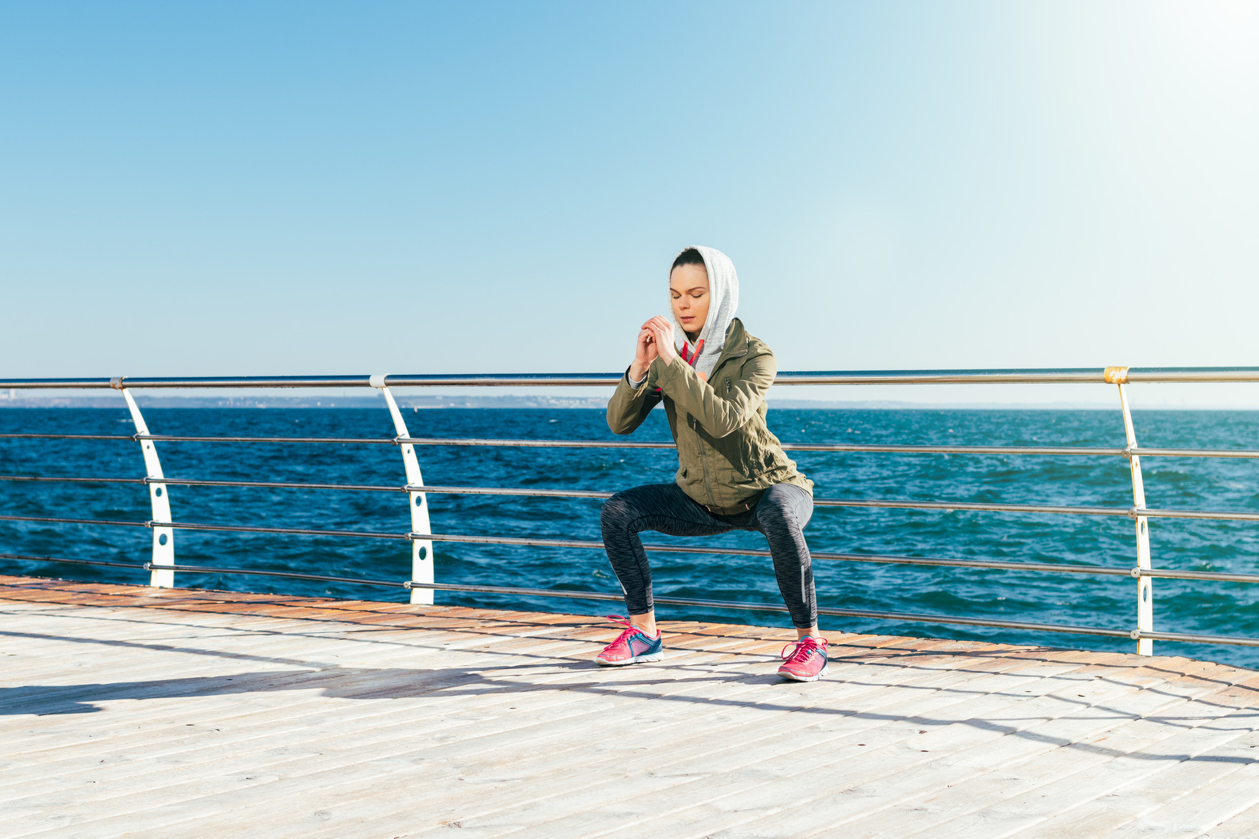 Sports woman in hood doing exercises, a Person Photo by progressman
