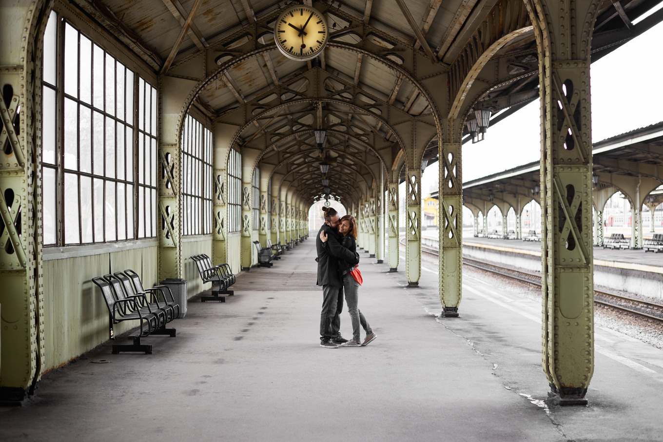 two hipster Lovers hug and kiss on the railway station. People love ...