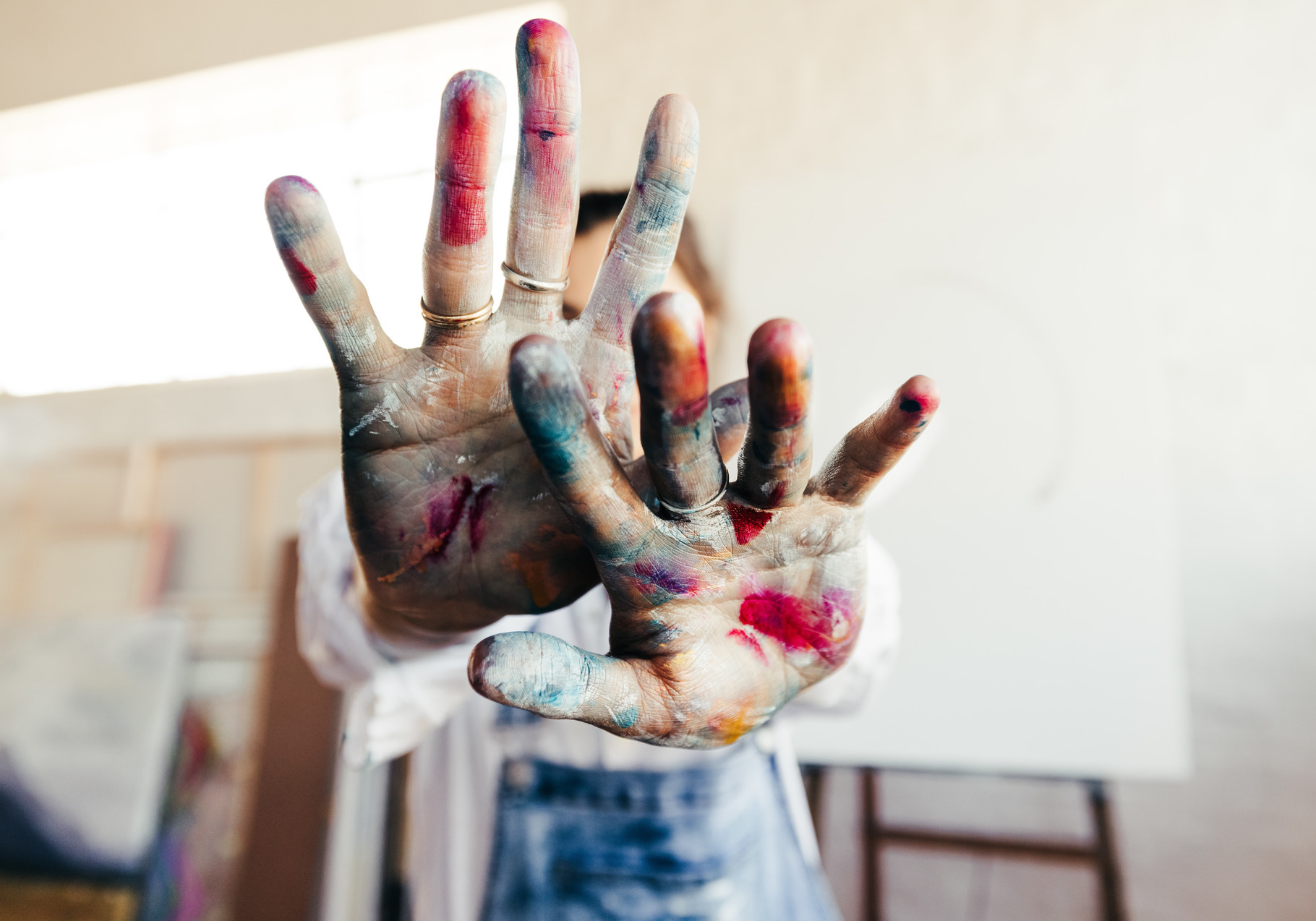 Painter blocking the camera with her colour painted hands, a Person ...