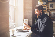 Young man drinking coffee in cafe, a Background Photo by Anastasia Dudka