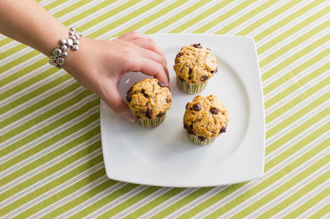 Hand taking chocolate chip muffin featuring hand, closeup, and detail ...