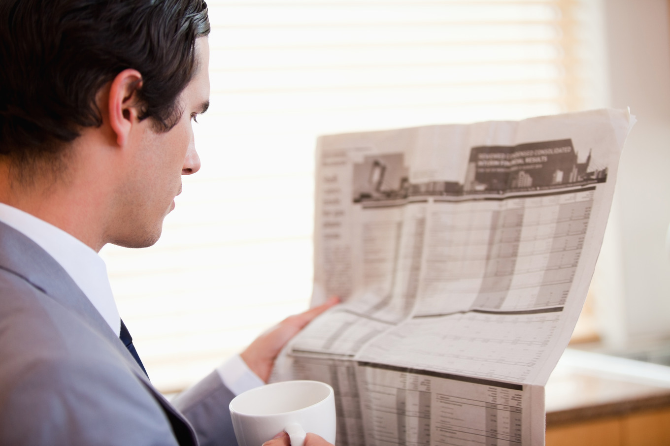 Side view of businessman reading newspaper, a Photo by wavebreak