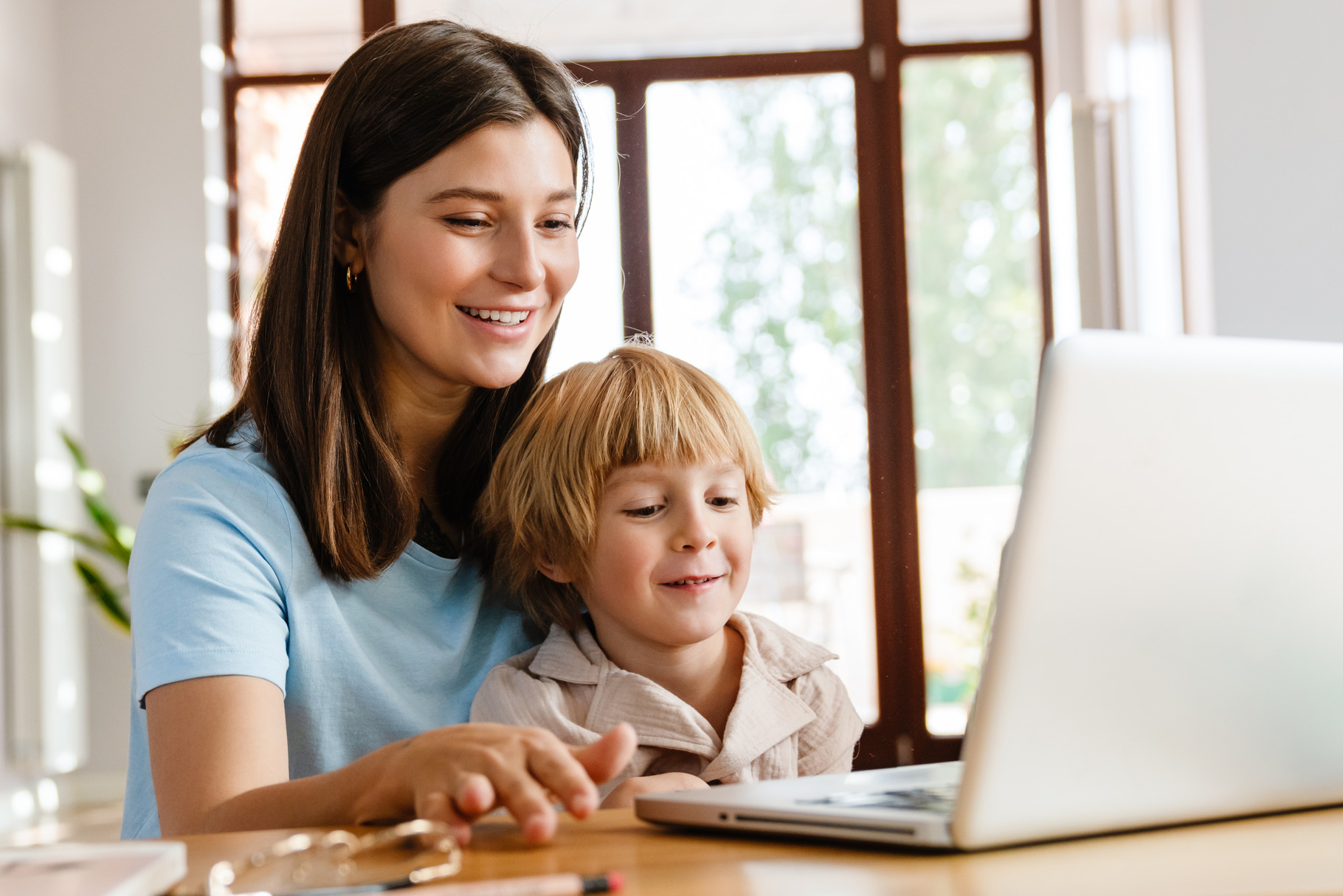 Woman at home with her son using laptop computer, a Person Photo by ...